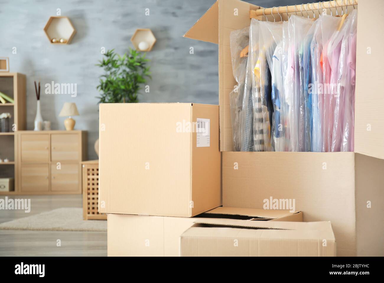 Wardrobe boxes with clothes indoors Stock Photo - Alamy