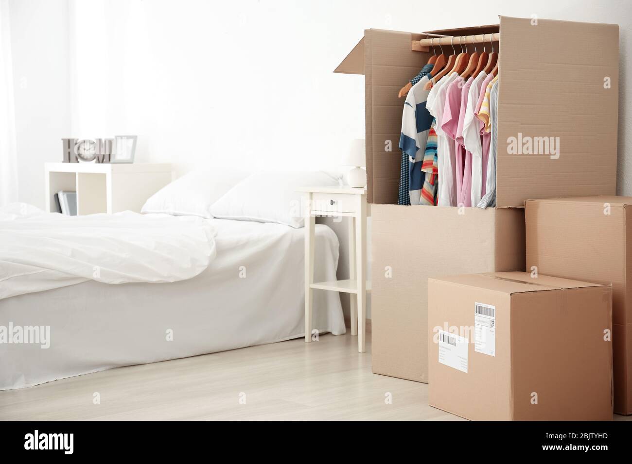 Wardrobe boxes with clothes indoors Stock Photo - Alamy