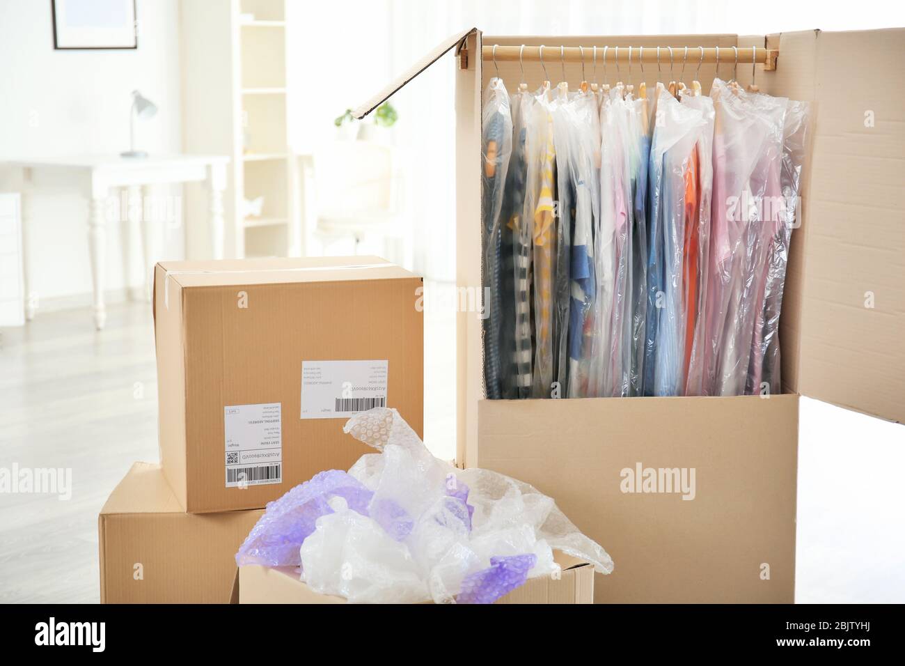 Wardrobe boxes with clothes indoors Stock Photo - Alamy