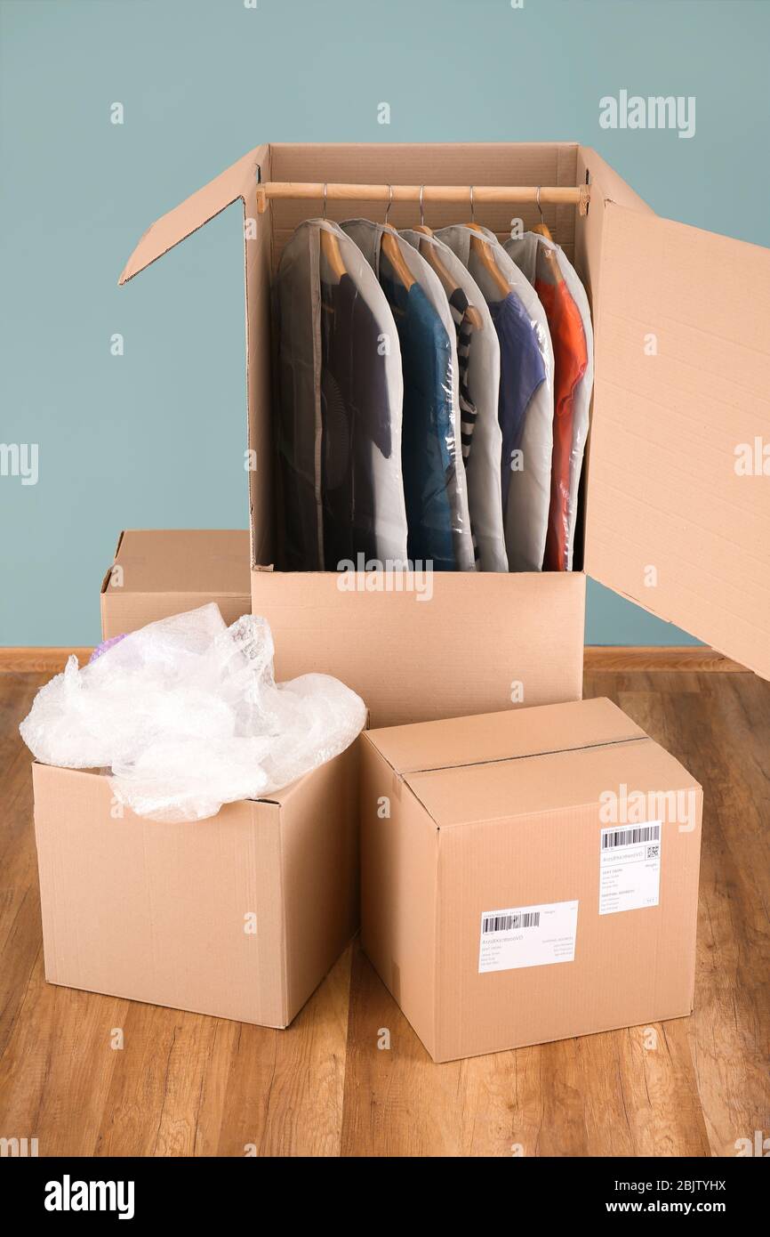 Wardrobe boxes with clothes indoors Stock Photo - Alamy
