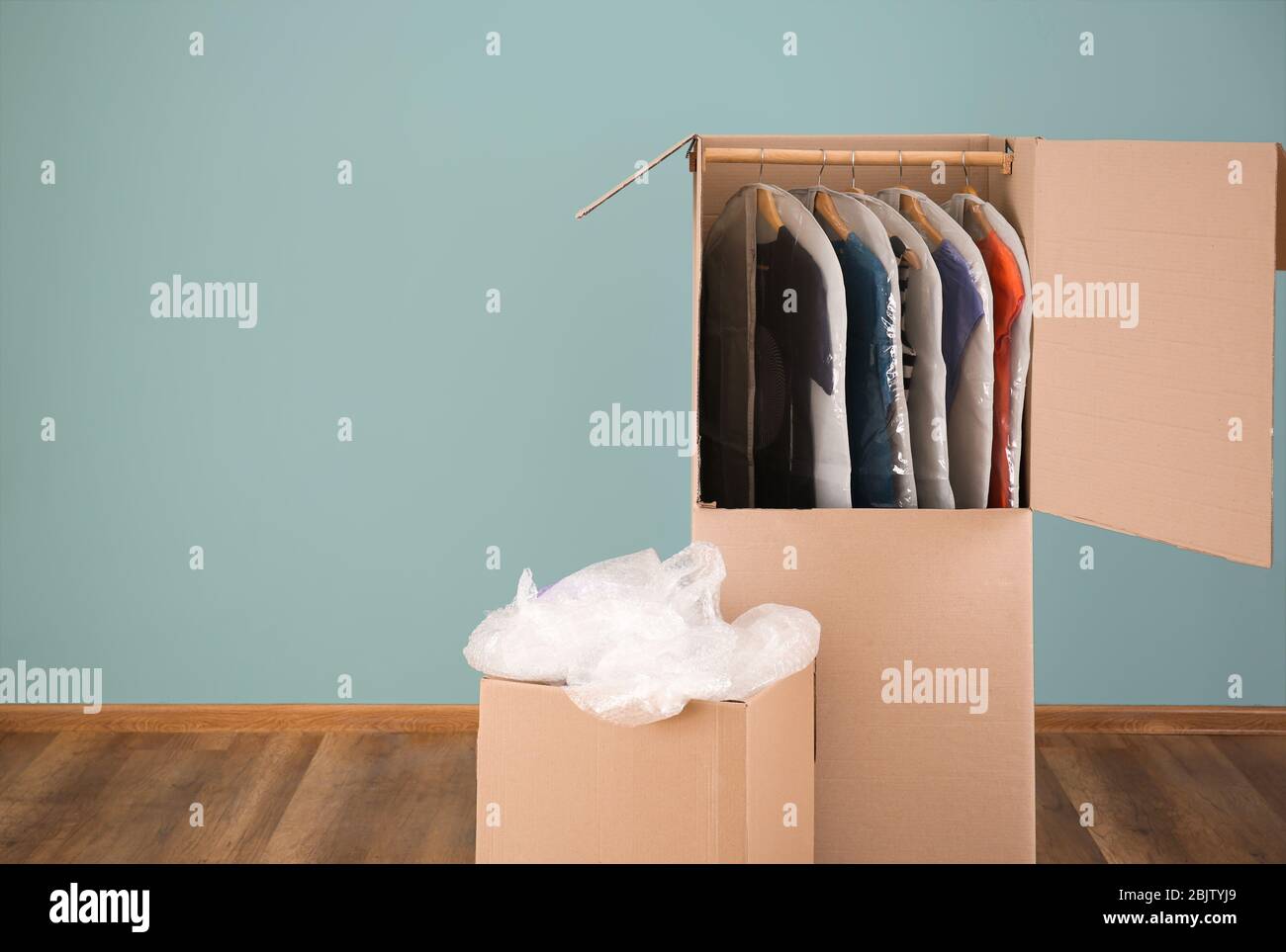 Wardrobe boxes with clothes indoors Stock Photo - Alamy