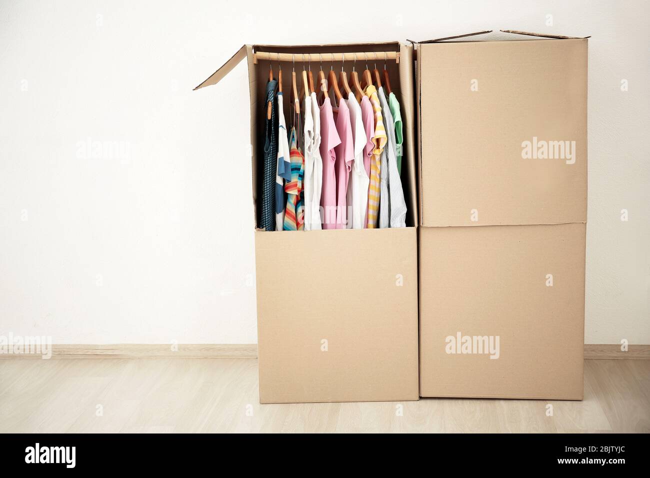 Wardrobe boxes with clothes indoors Stock Photo - Alamy
