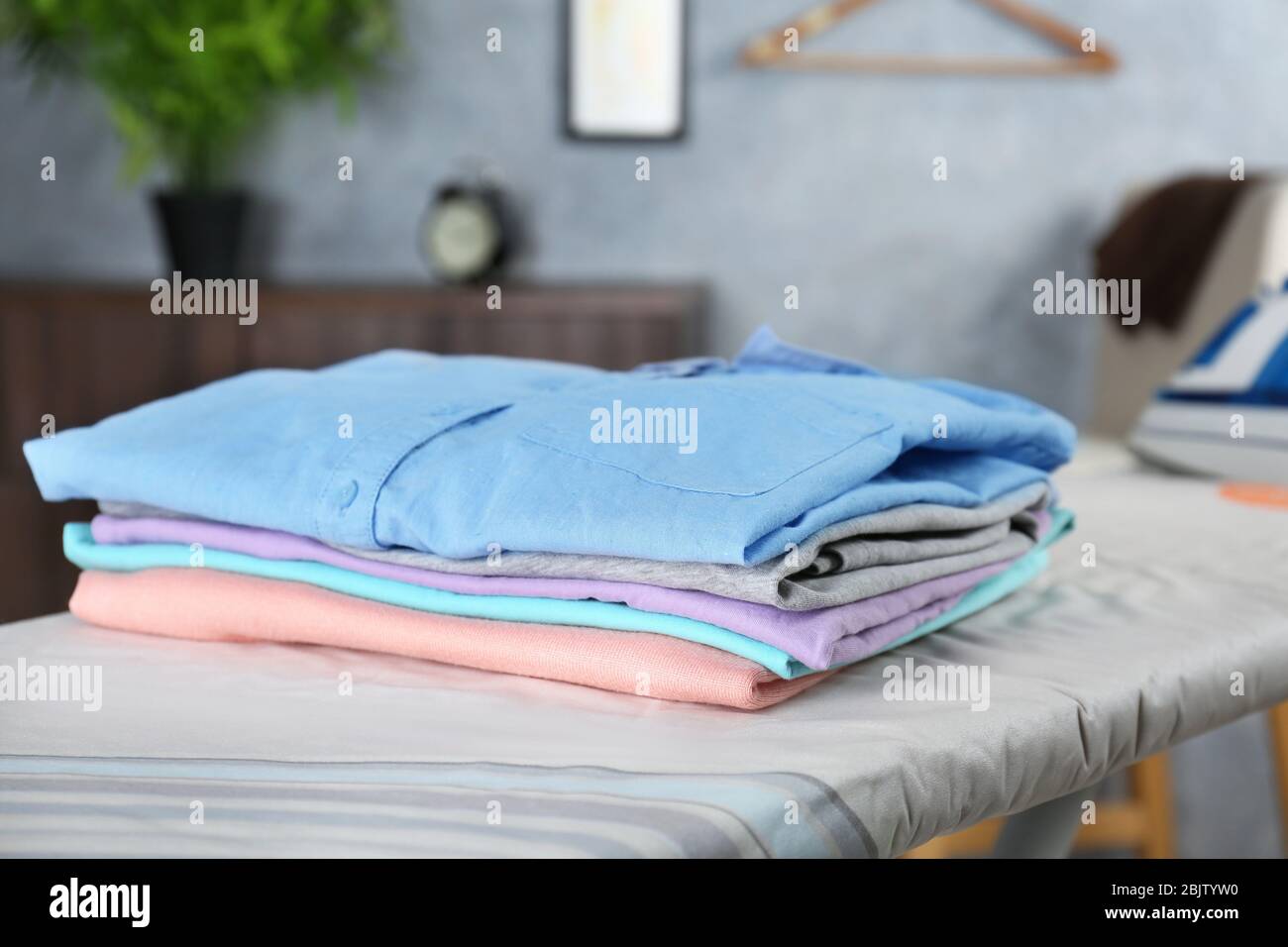 Stack of laundry on ironing board, indoors Stock Photo - Alamy