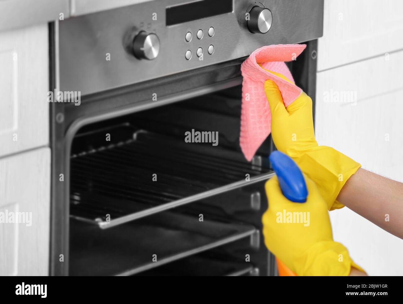 Man cleaning oven in kitchen, closeup Stock Photo - Alamy