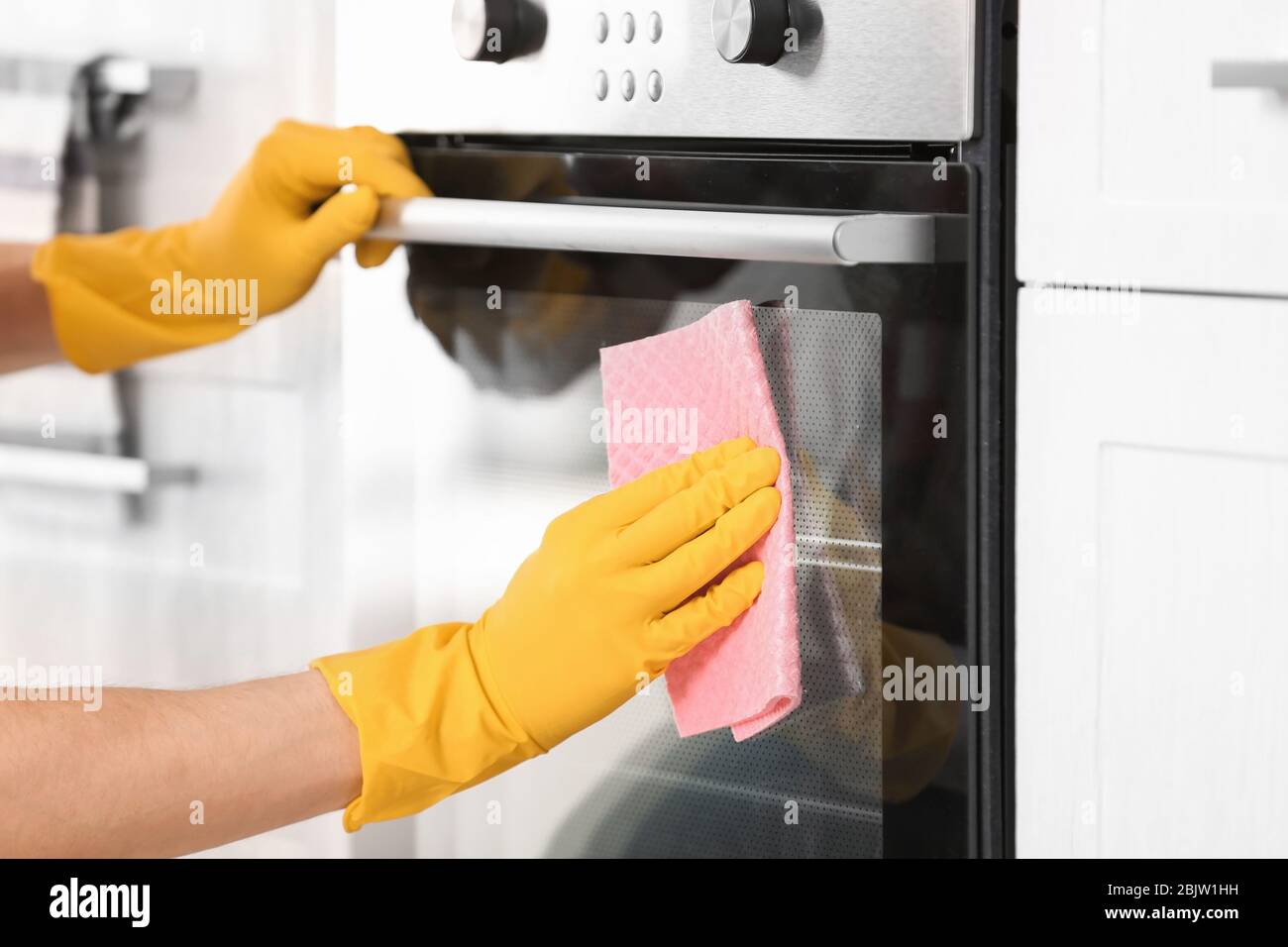 Man cleaning oven in kitchen, closeup Stock Photo - Alamy