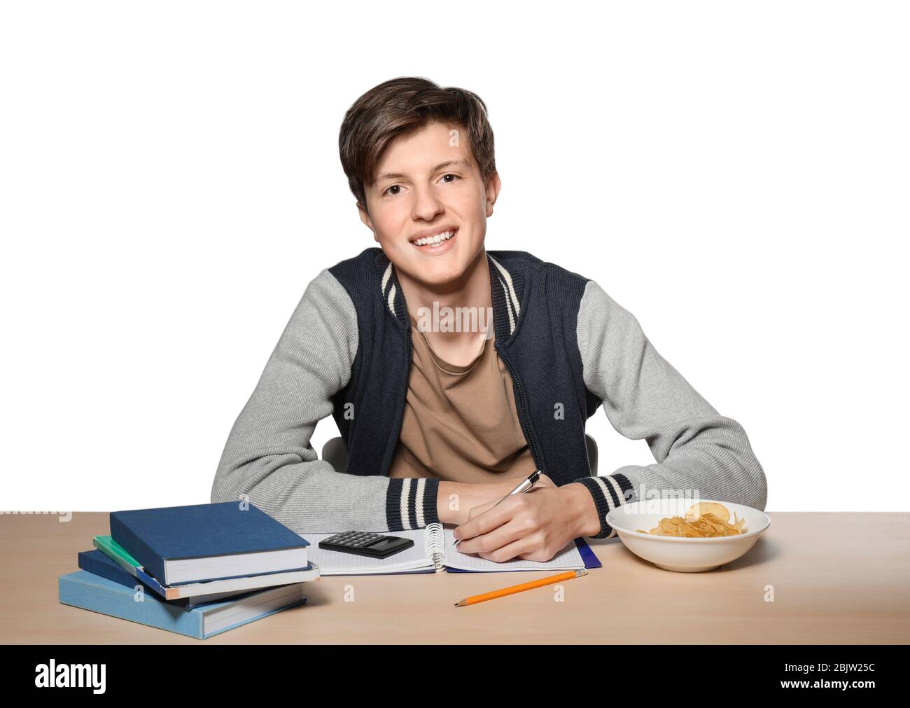 Cute teenager boy doing homework against white background Stock Photo ...