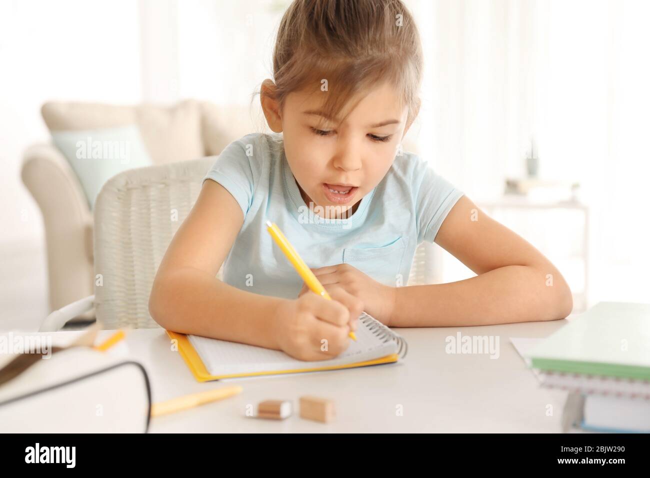 Cute little girl doing homework indoors Stock Photo - Alamy