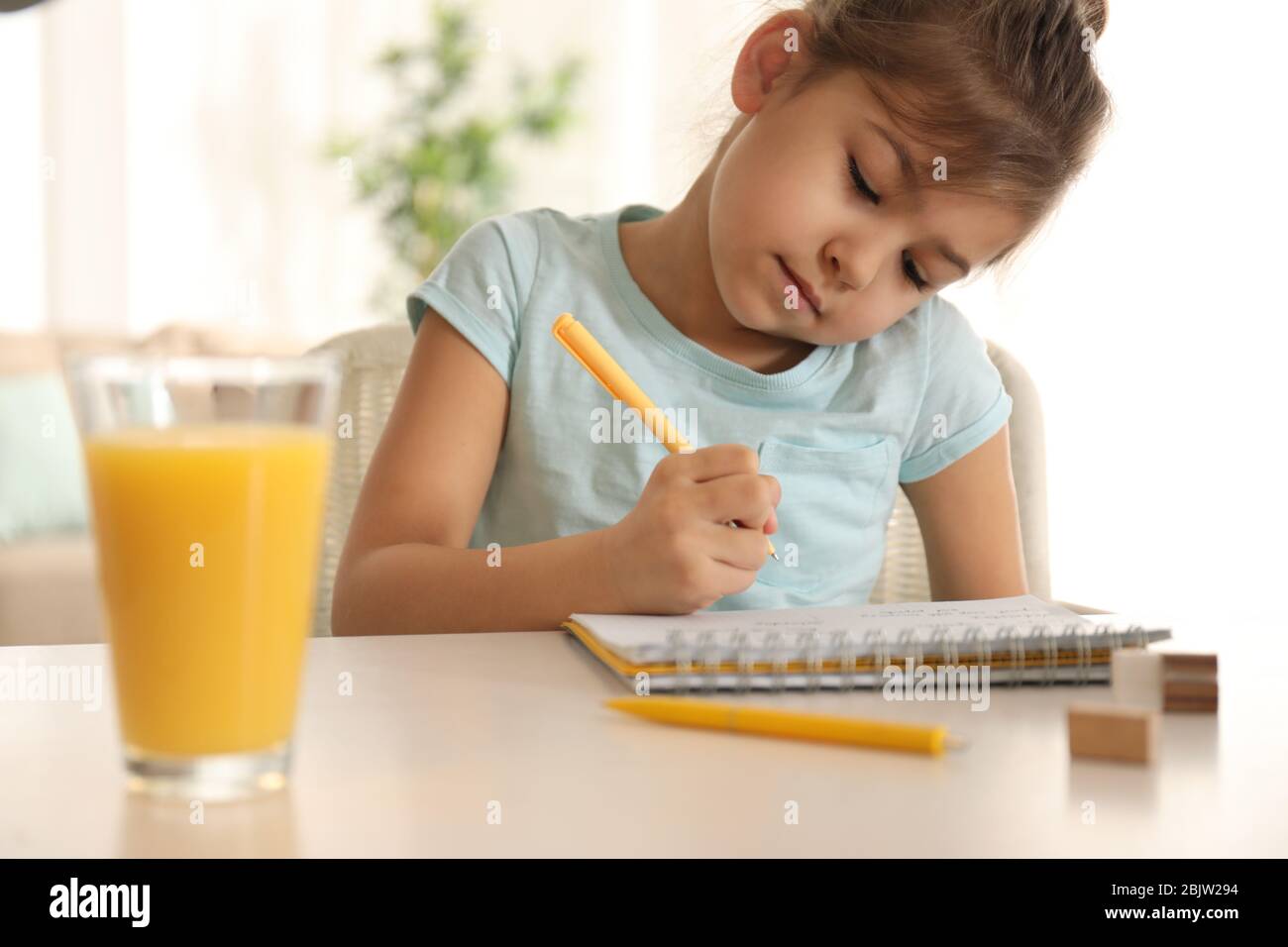 Cute little girl doing homework indoors Stock Photo - Alamy