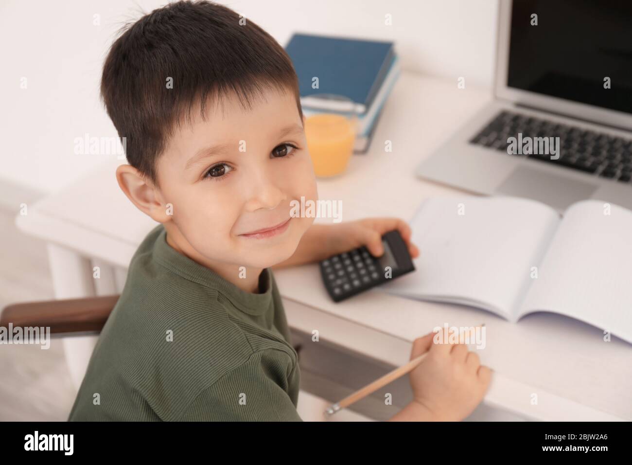 Cute little boy doing homework indoors Stock Photo - Alamy