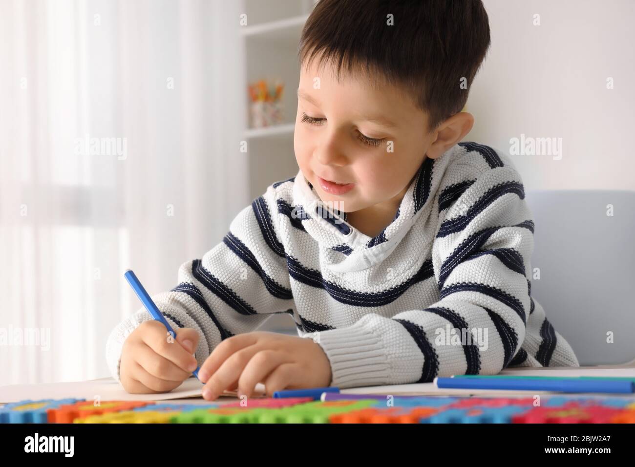 Cute little boy doing homework indoors Stock Photo - Alamy