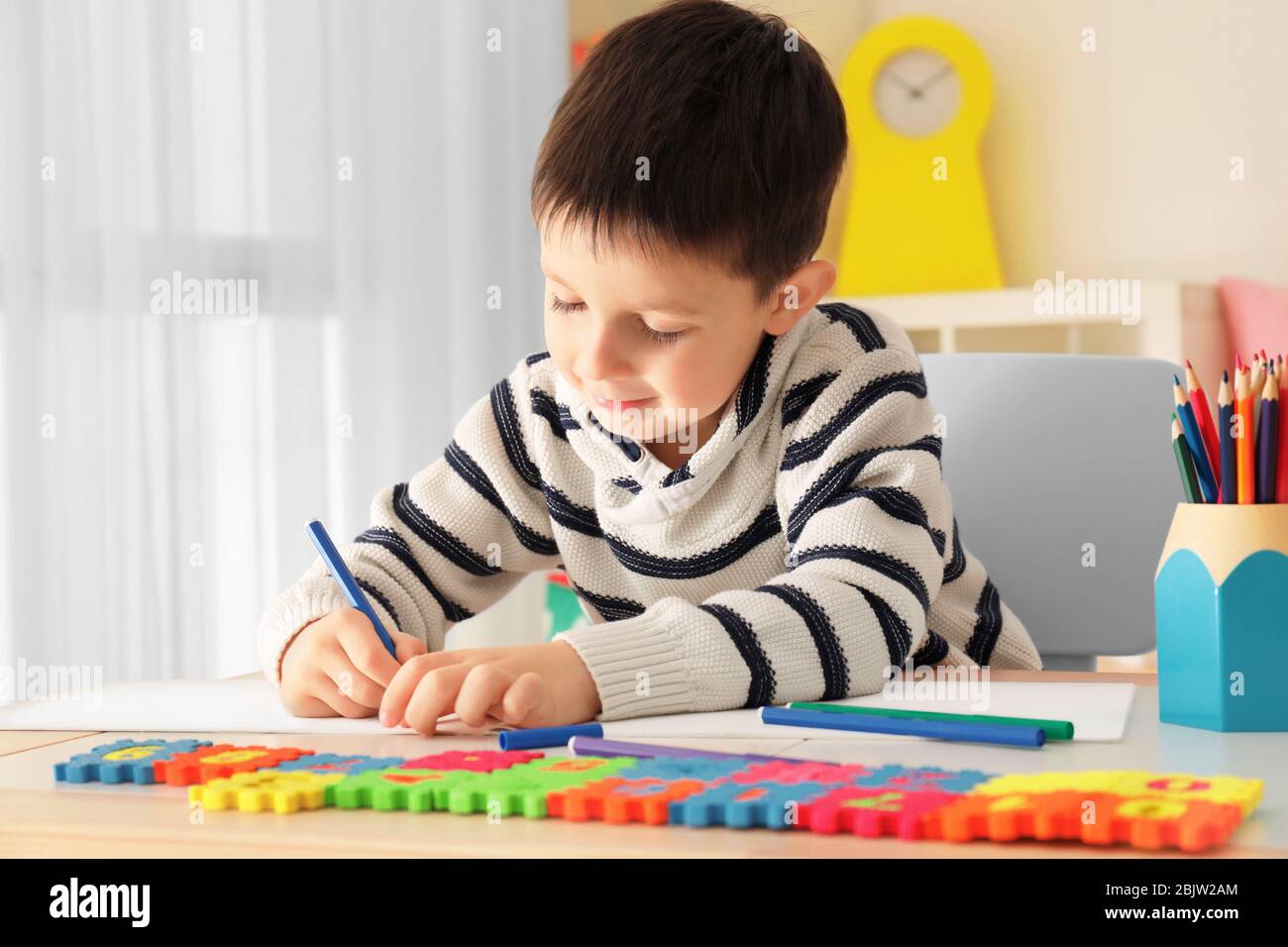 Cute little boy doing homework indoors Stock Photo - Alamy