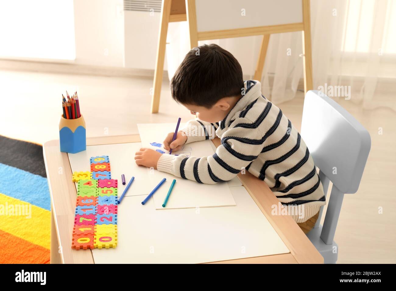 Cute little boy doing homework indoors Stock Photo - Alamy