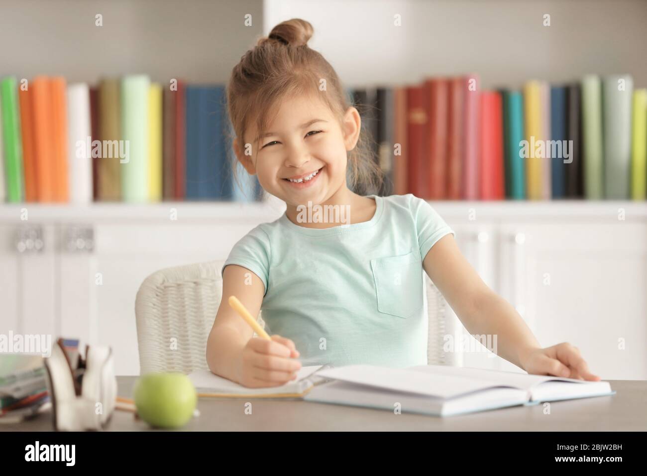 Cute little girl doing homework indoors Stock Photo - Alamy