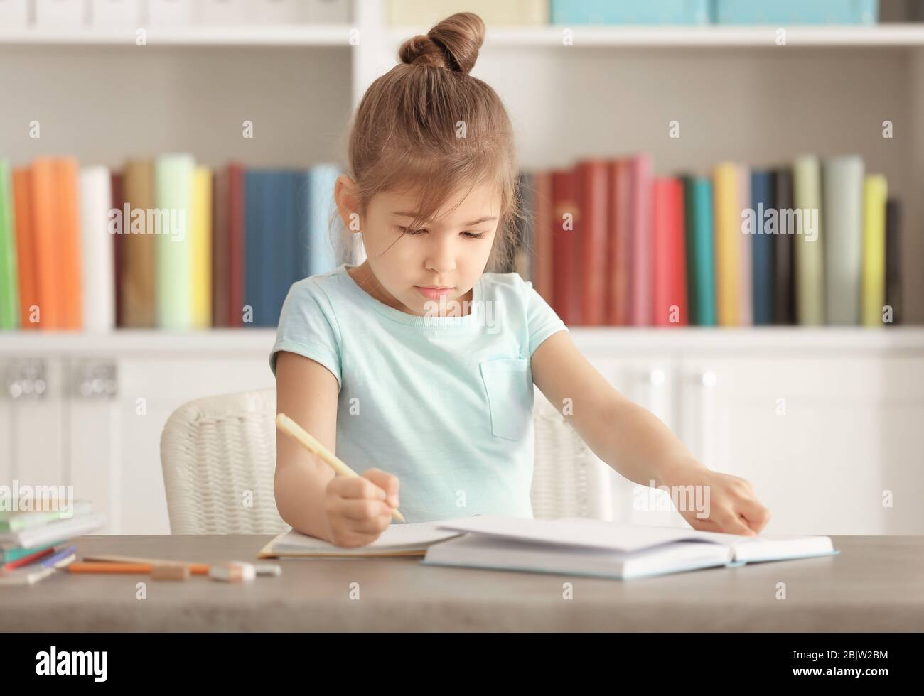 Cute little girl doing homework indoors Stock Photo - Alamy