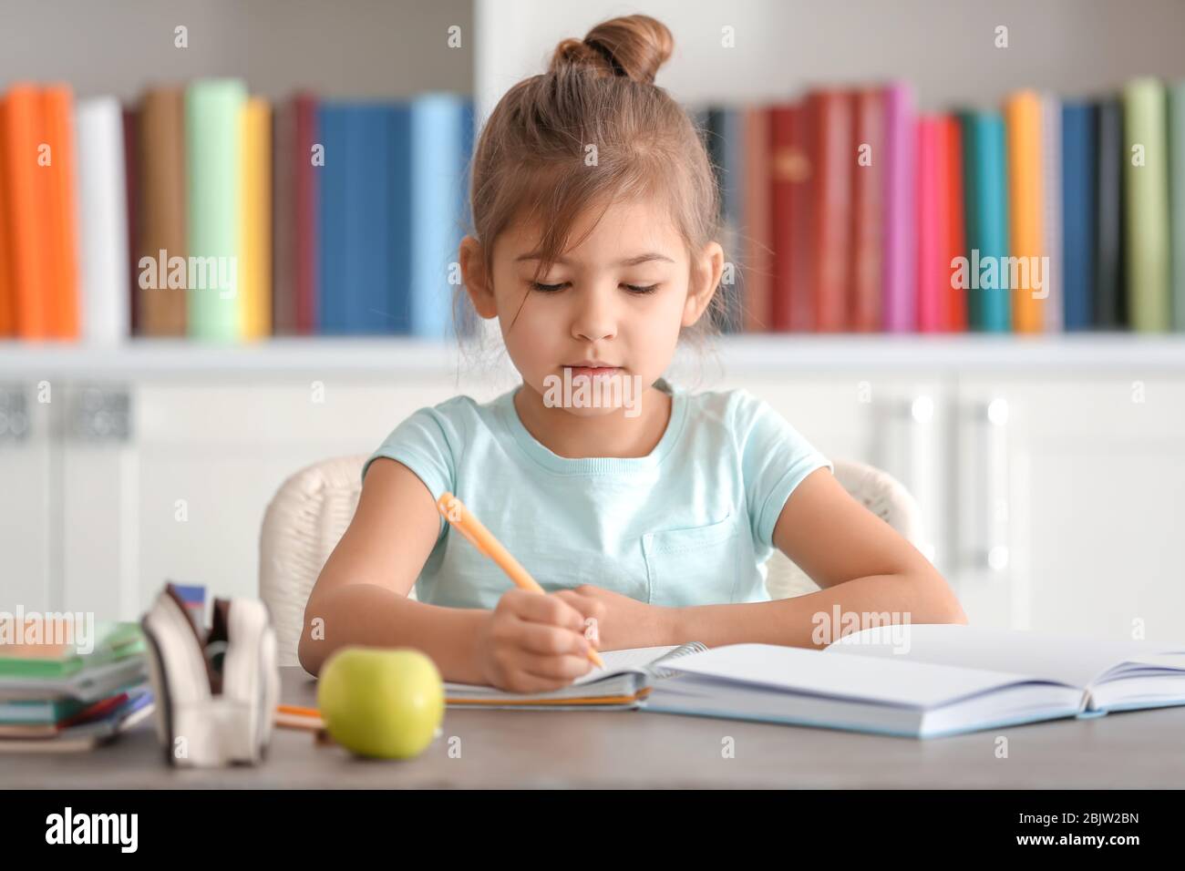 Cute little girl doing homework indoors Stock Photo - Alamy