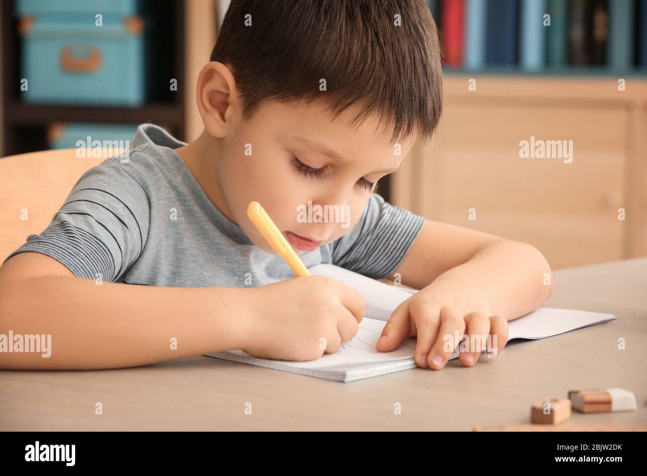 Cute little boy doing homework indoors Stock Photo - Alamy