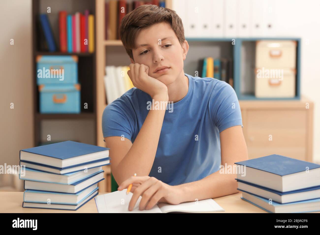 Exhausted boy doing homework library hi-res stock photography and ...