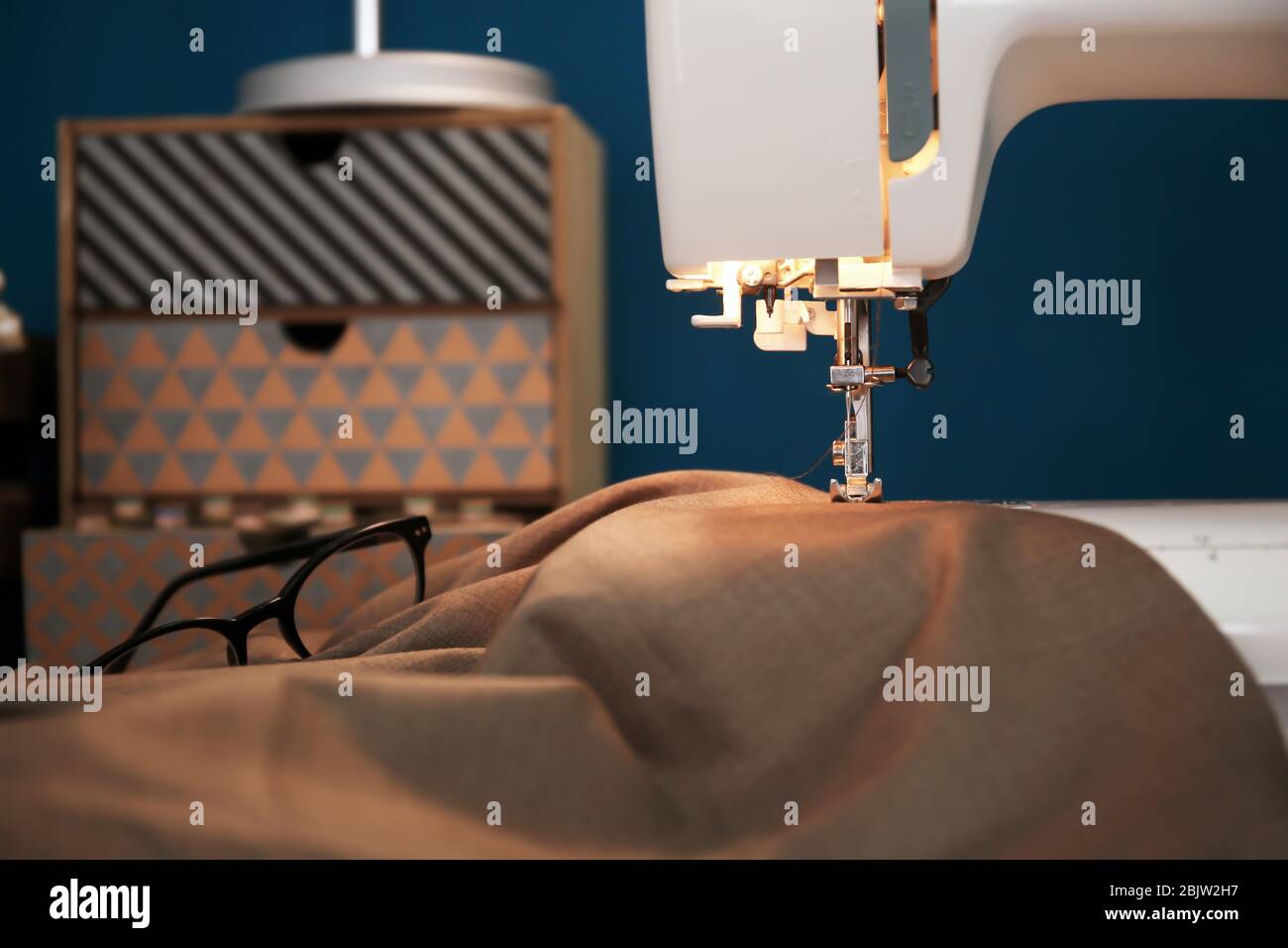 Tailor desk with modern sewing machine Stock Photo - Alamy