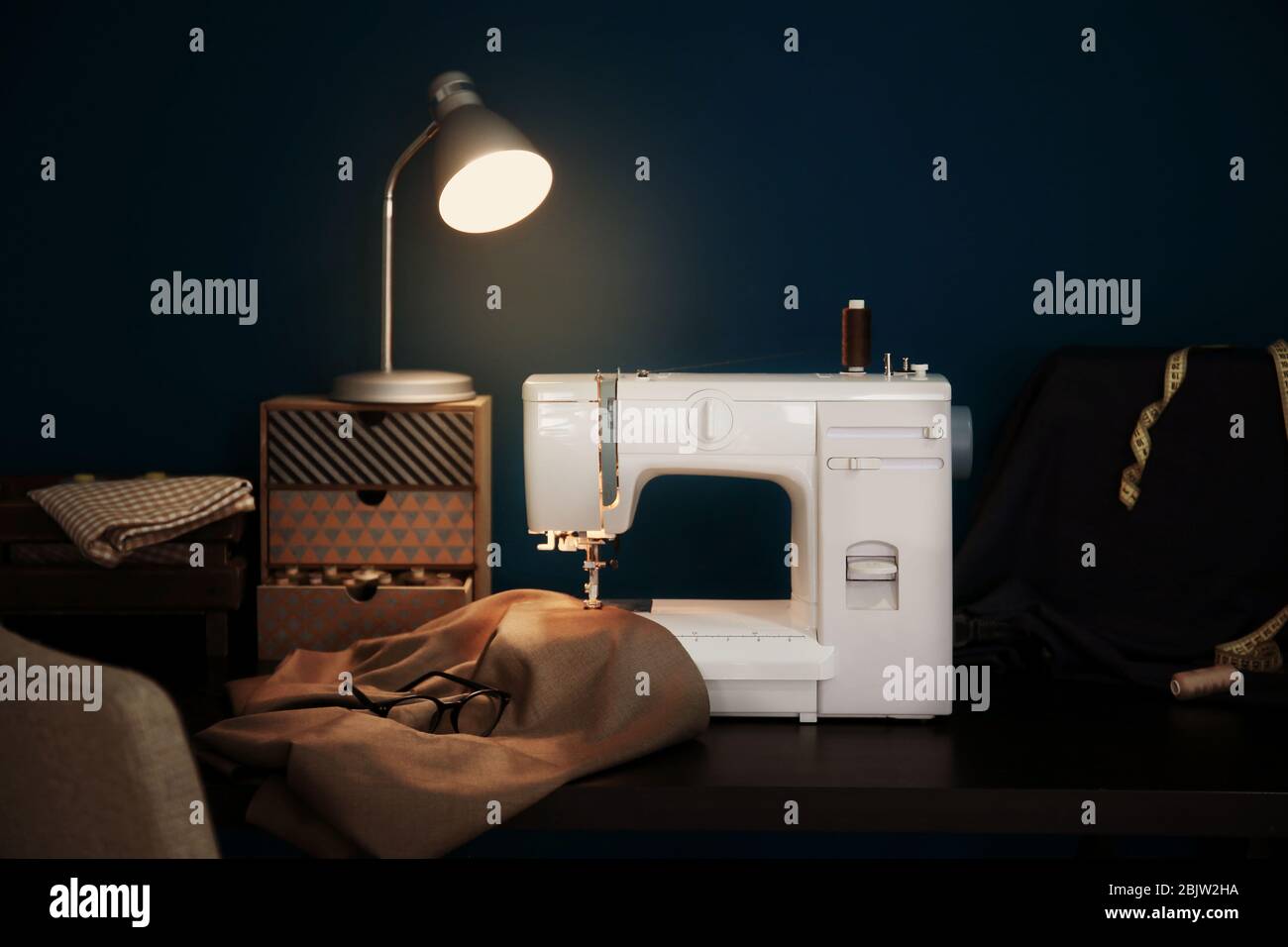 Tailor desk with modern sewing machine Stock Photo - Alamy