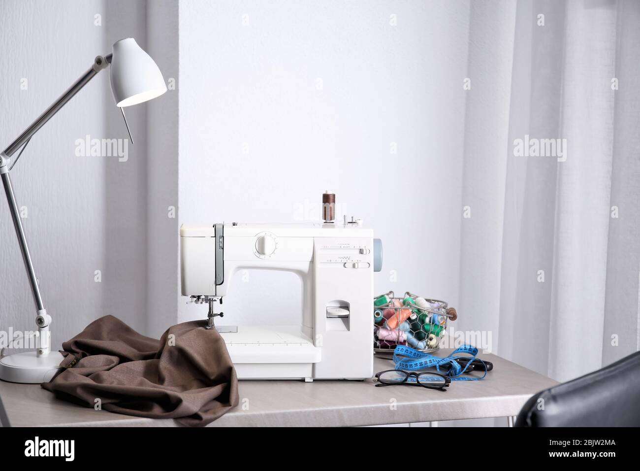 Tailor desk with modern sewing machine Stock Photo - Alamy