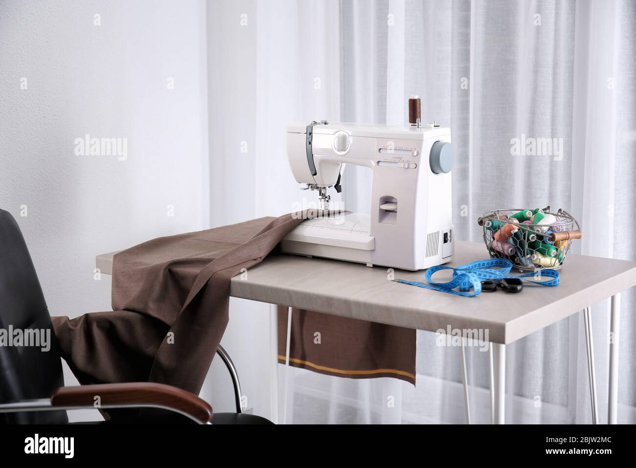 Tailor workshop with modern sewing machine Stock Photo - Alamy