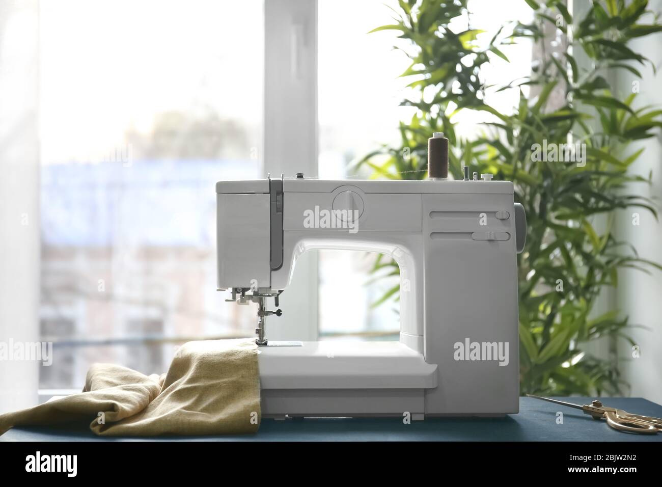 Tailor desk with modern sewing machine Stock Photo - Alamy