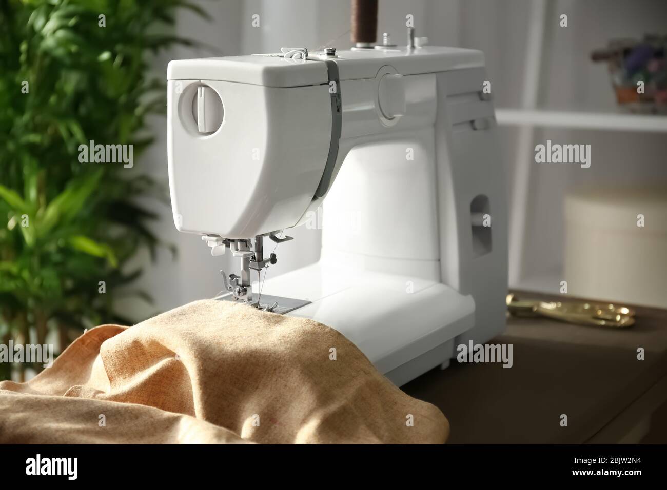 Tailor desk with modern sewing machine Stock Photo - Alamy