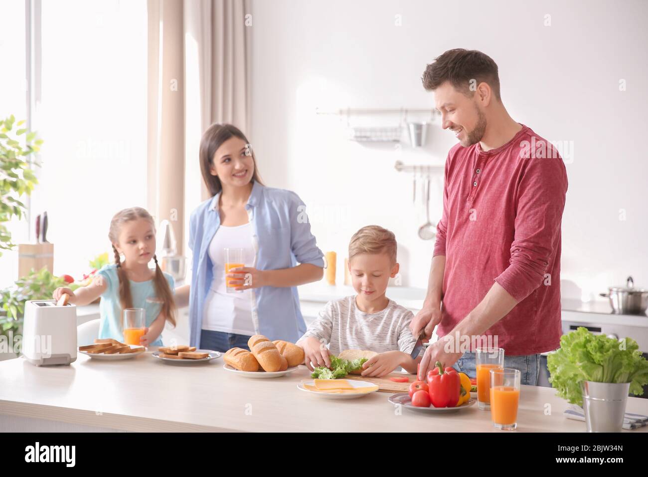 Happy family having breakfast with toasts in kitchen Stock Photo - Alamy