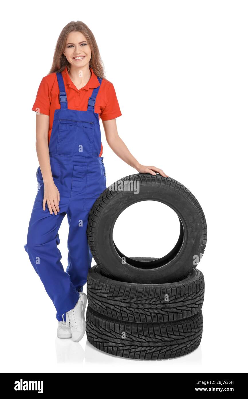 Female mechanic in uniform with car tires on white background Stock ...