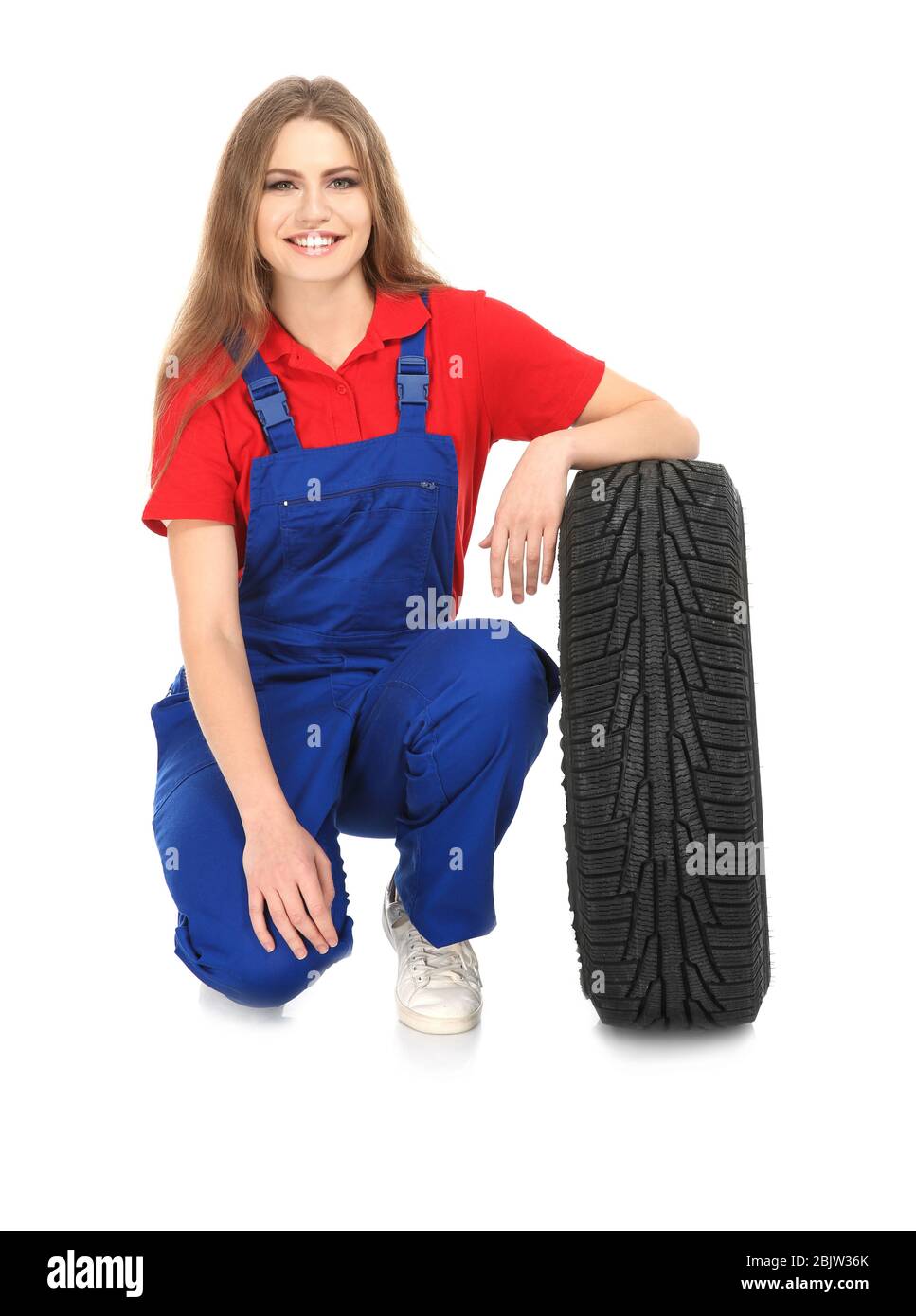 Female mechanic in uniform with car tire on white background Stock ...