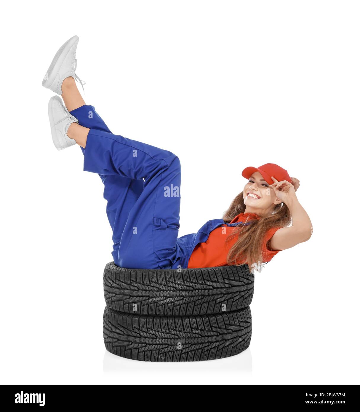 Female mechanic in uniform with car tires on white background Stock ...