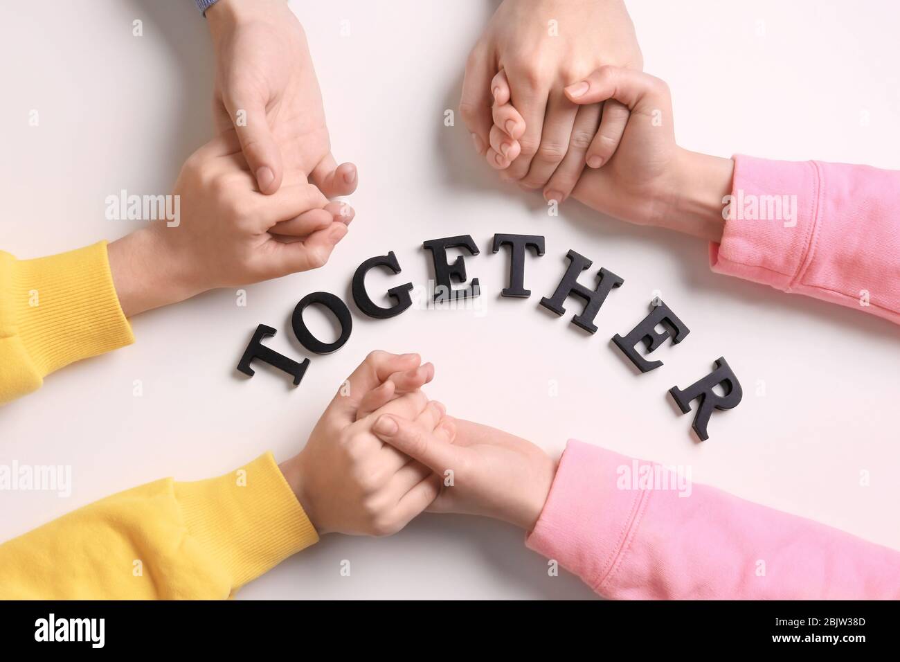 People holding hands and word TOGETHER made of letters on white ...