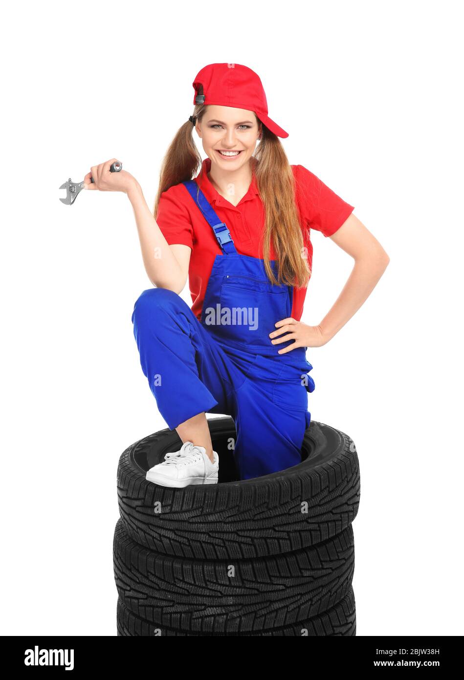 Female mechanic in uniform with car tires on white background Stock ...