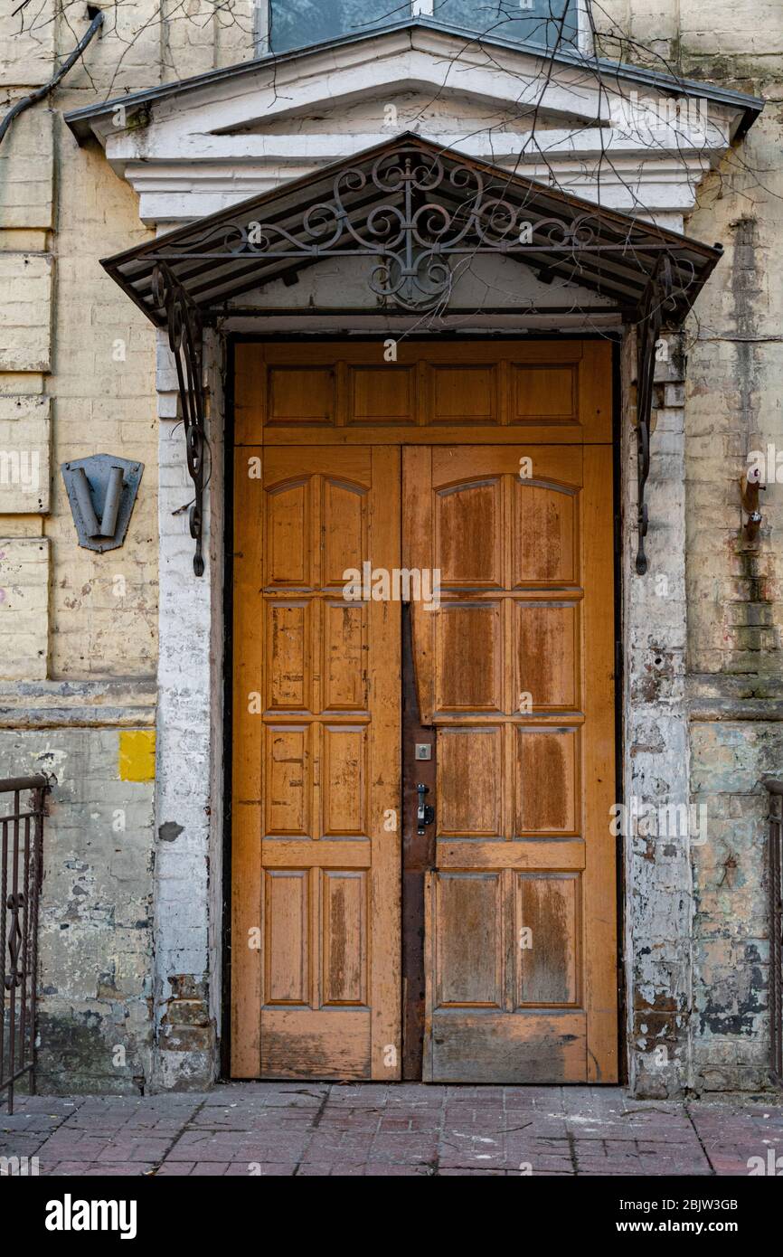 Antique ornate triangle shape metal porch and weathered wooden door in ...