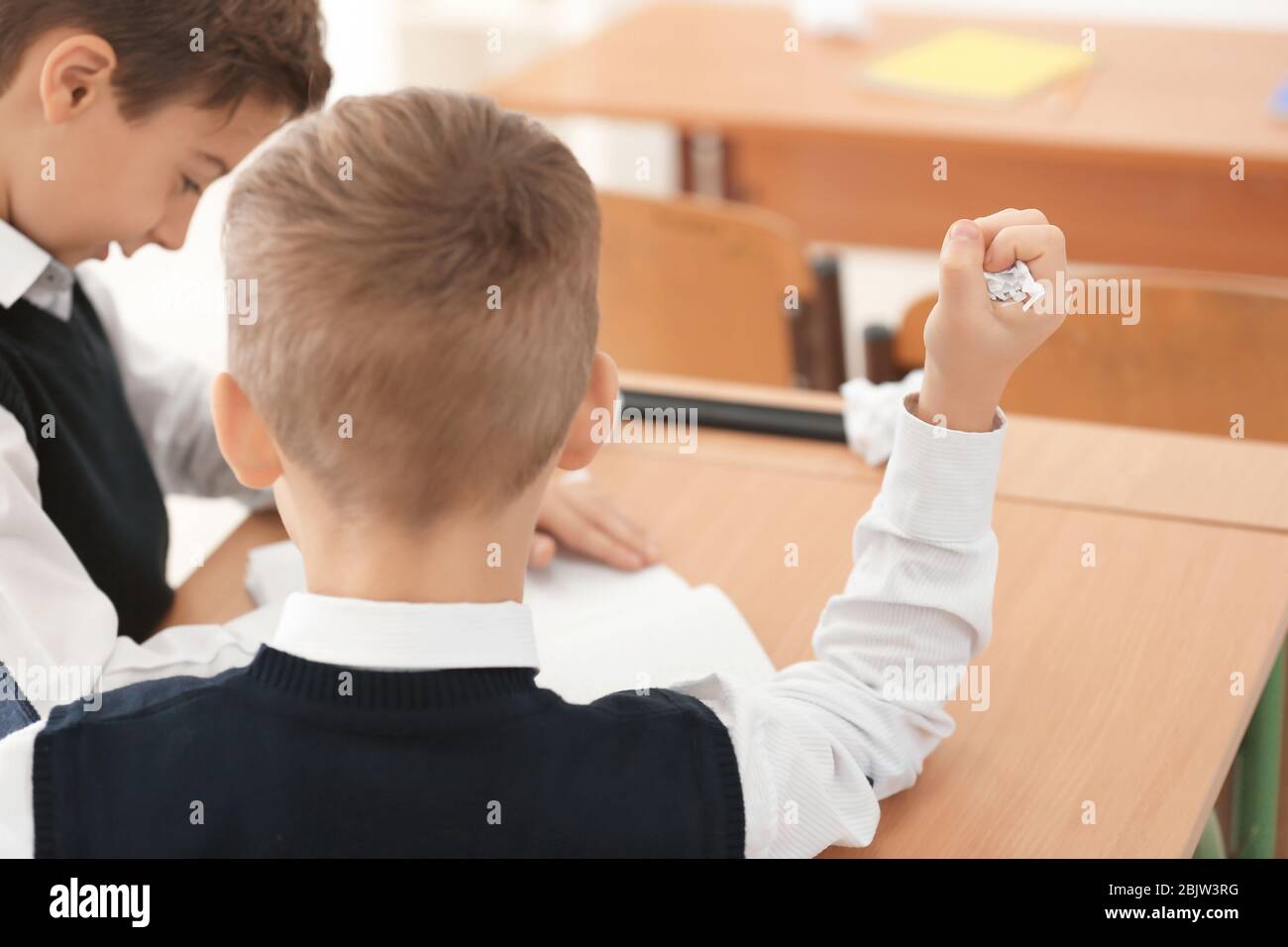 Little boy making paper ball in classroom Stock Photo - Alamy