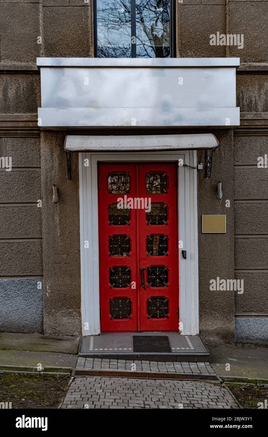 Ornate red double door with rows of square shape windows and patterned ...