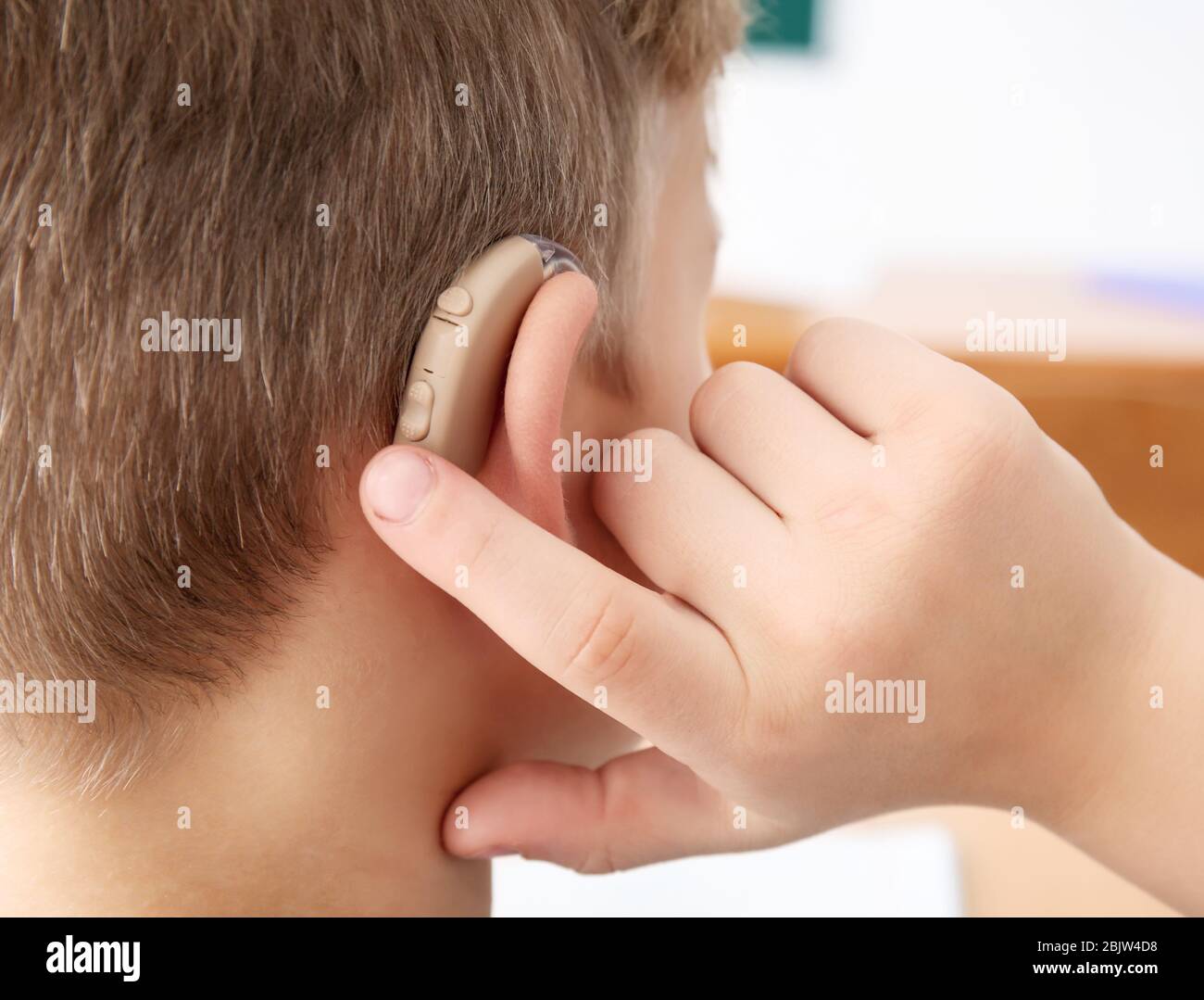 Little boy turning on hearing aid, closeup Stock Photo - Alamy