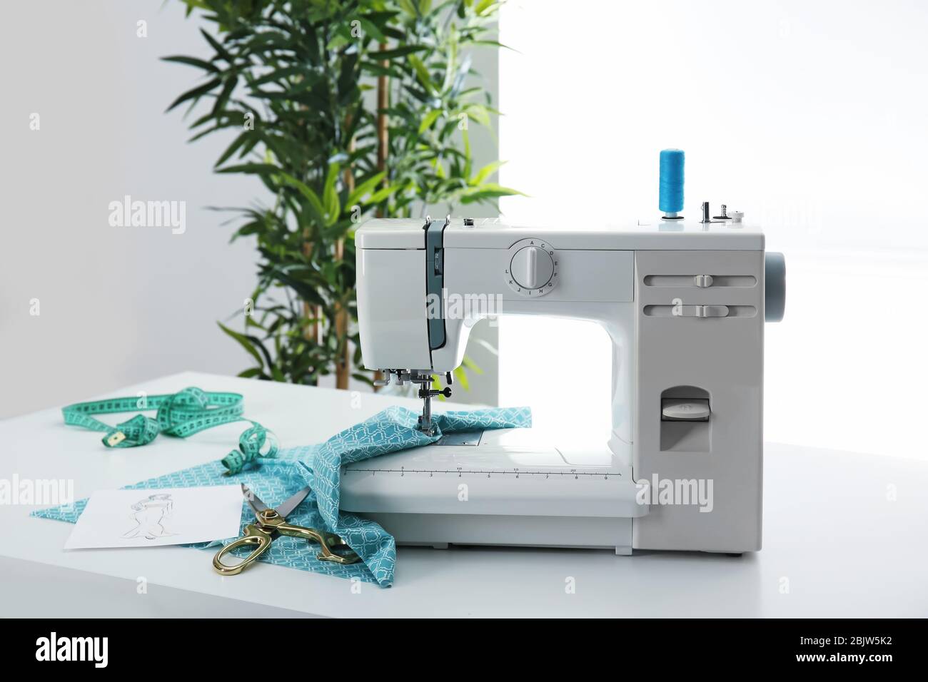 Sewing machine with thread and fabric on table Stock Photo - Alamy