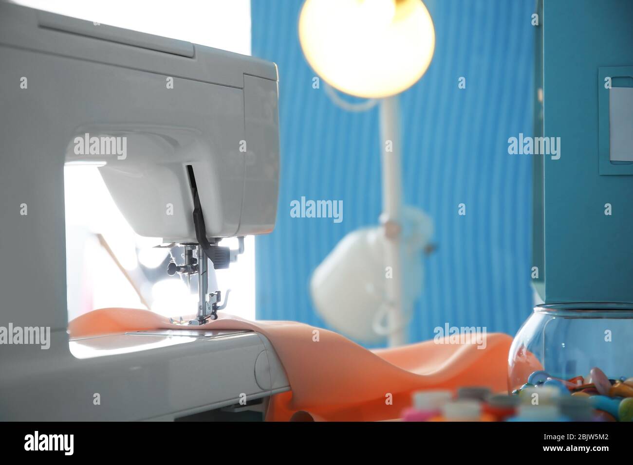 Sewing machine with fabric on table in tailor workshop Stock Photo - Alamy