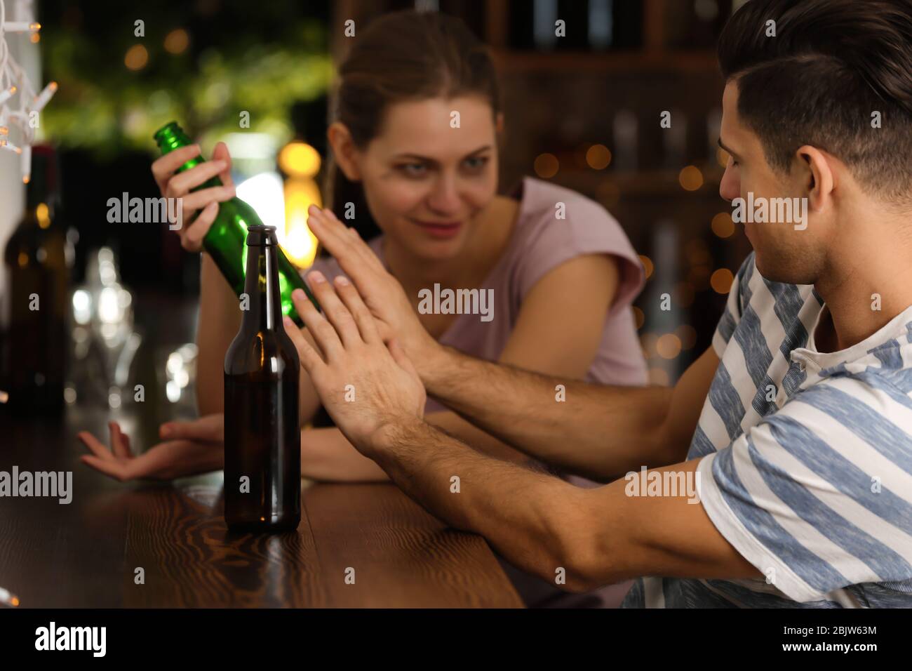Young man refusing to drink beer in bar. Alcoholism problem Stock Photo ...