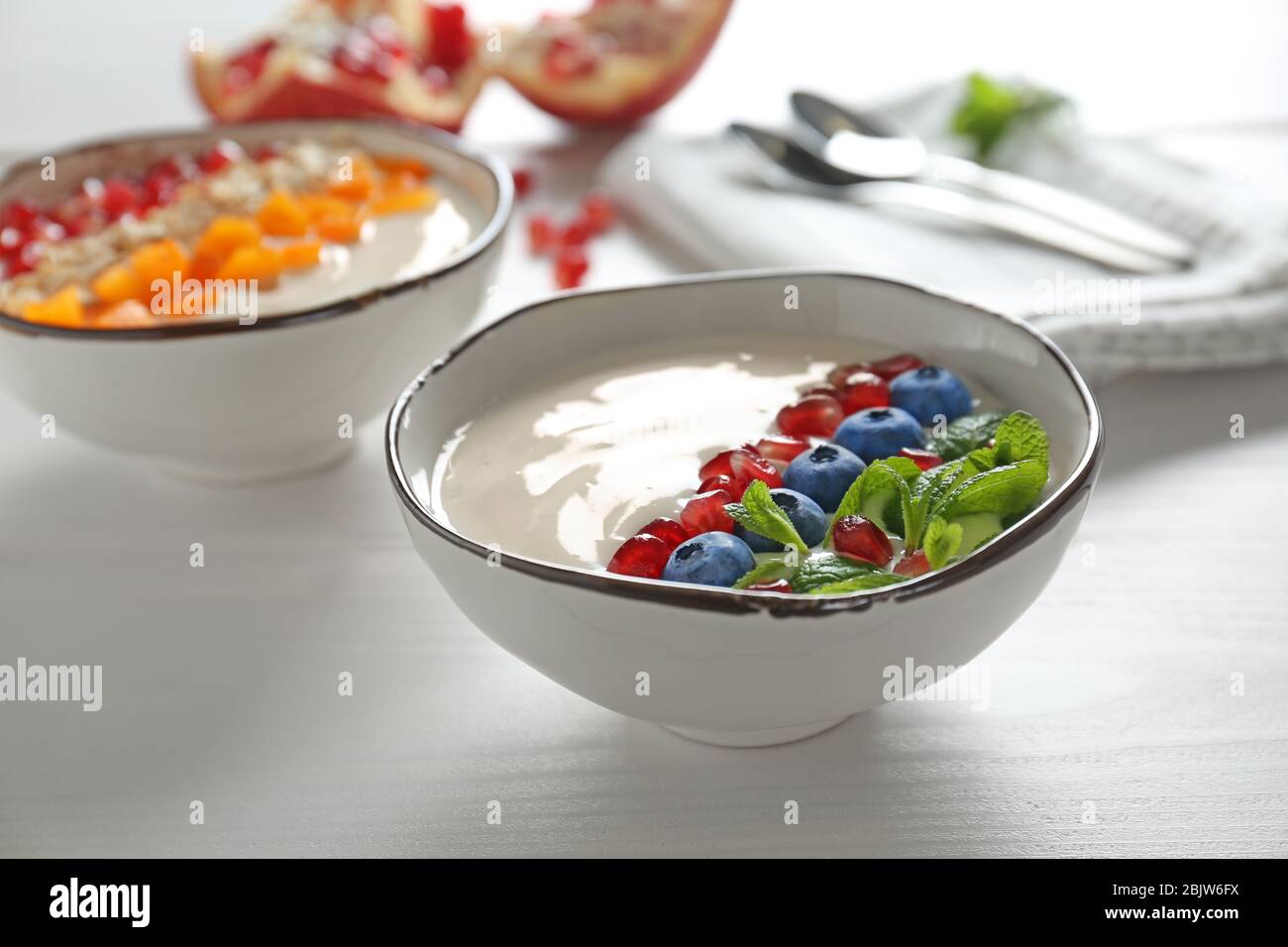 Yogurt with fruits in dishes on wooden table Stock Photo - Alamy