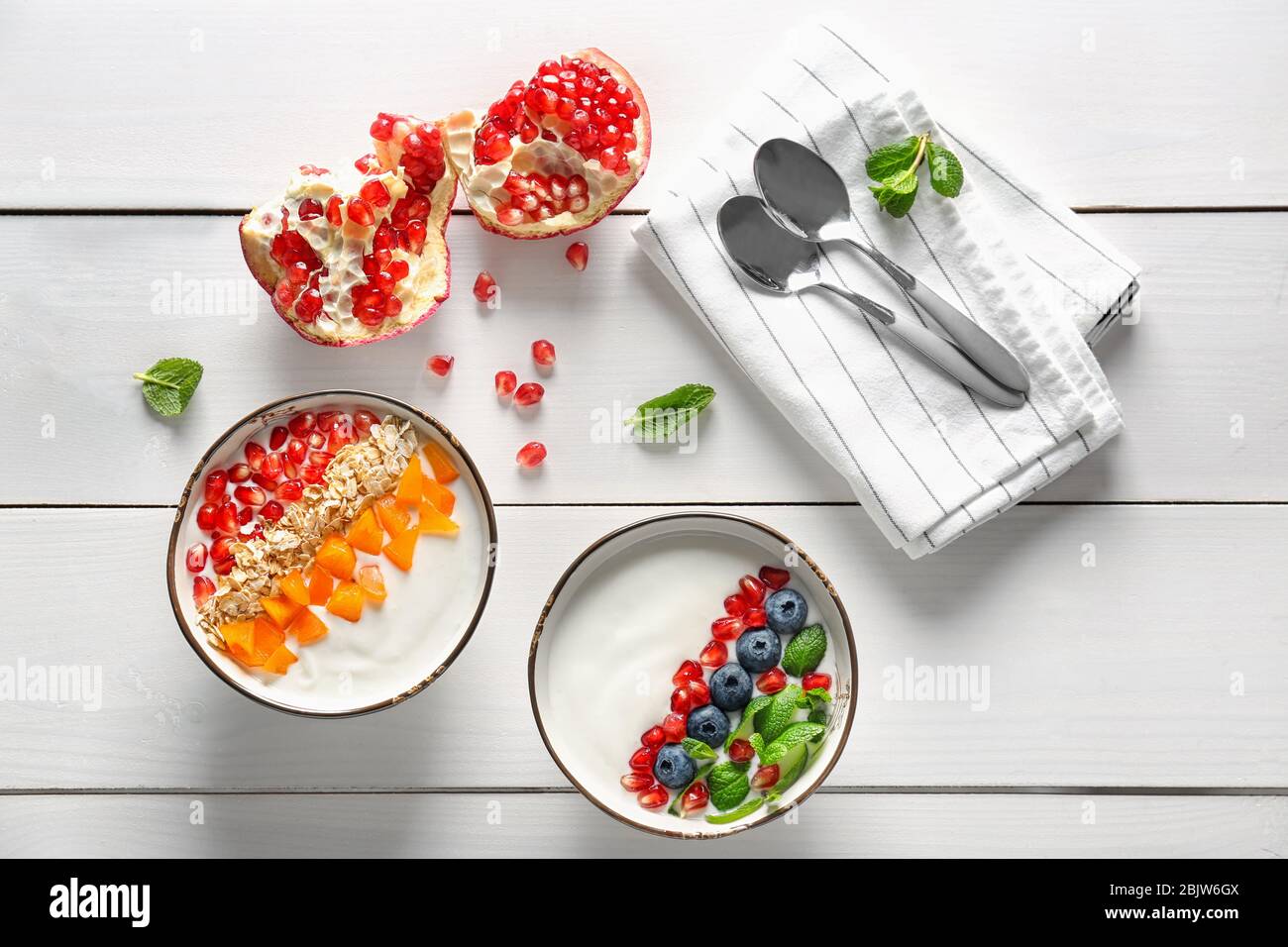 Yogurt with fruits in dishes on wooden table Stock Photo - Alamy