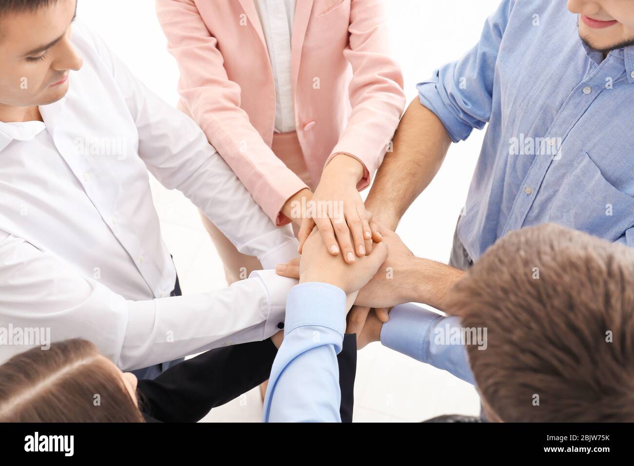 Young people putting hands together, closeup. Unity concept Stock Photo ...