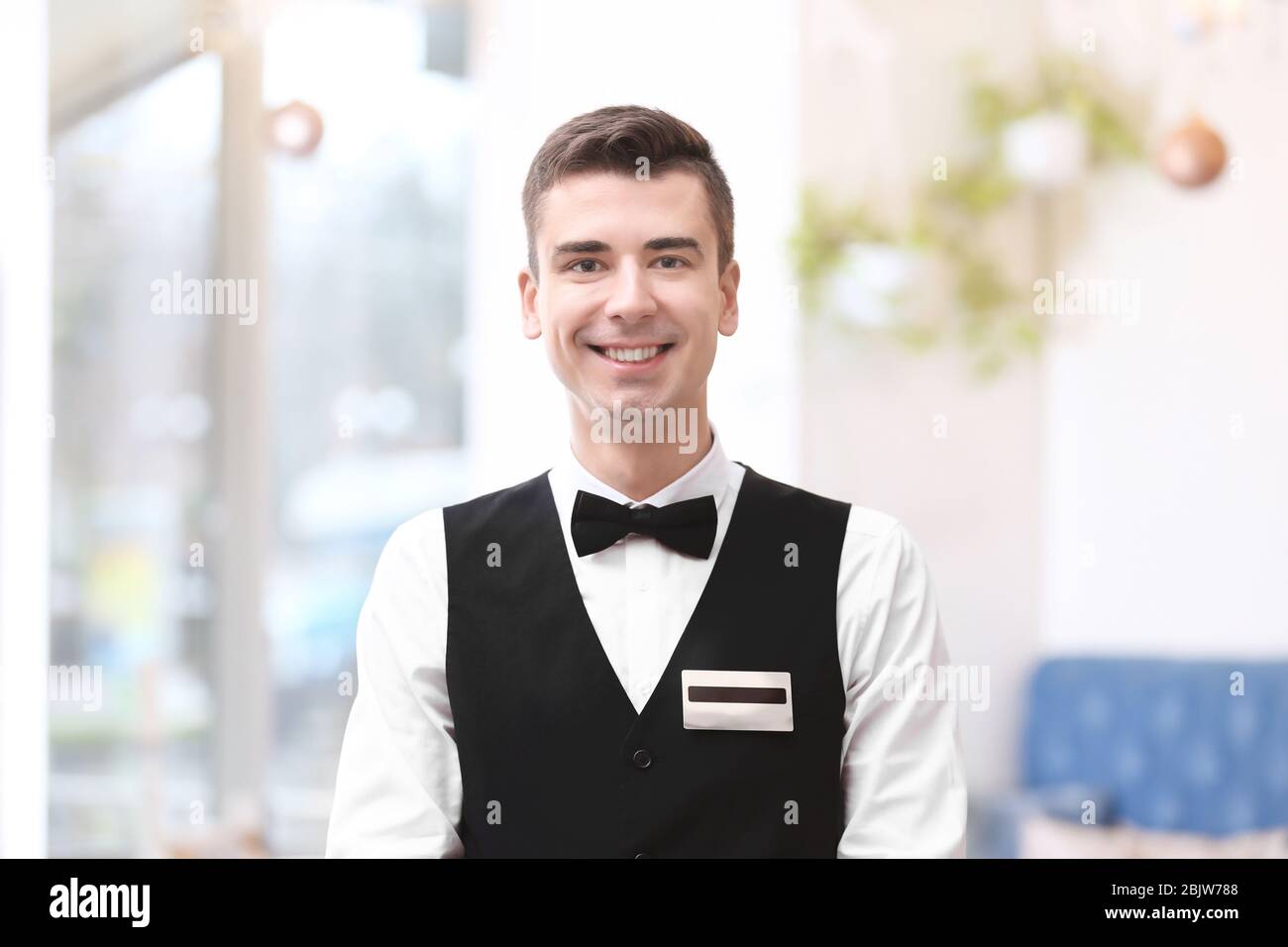 Attractive young waiter at workplace Stock Photo - Alamy