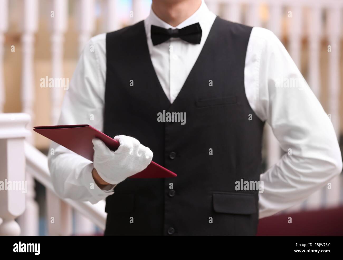 Waiter with menu at workplace Stock Photo - Alamy