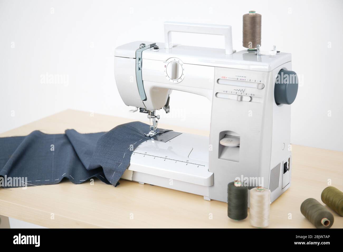 Sewing machine on table in tailor's workshop Stock Photo - Alamy