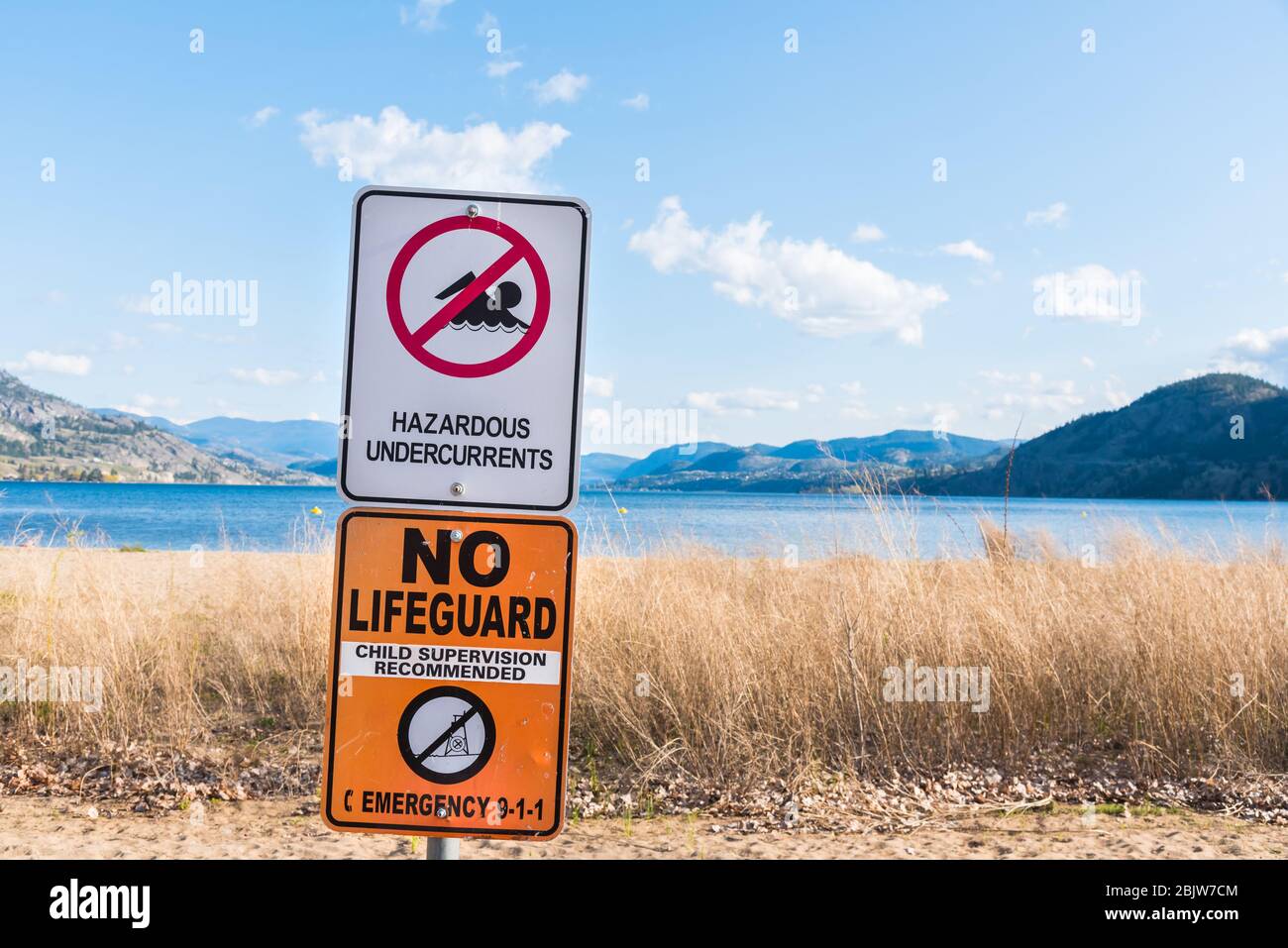 Water safety sign warning of hazardous undercurrents and no lifeguard ...