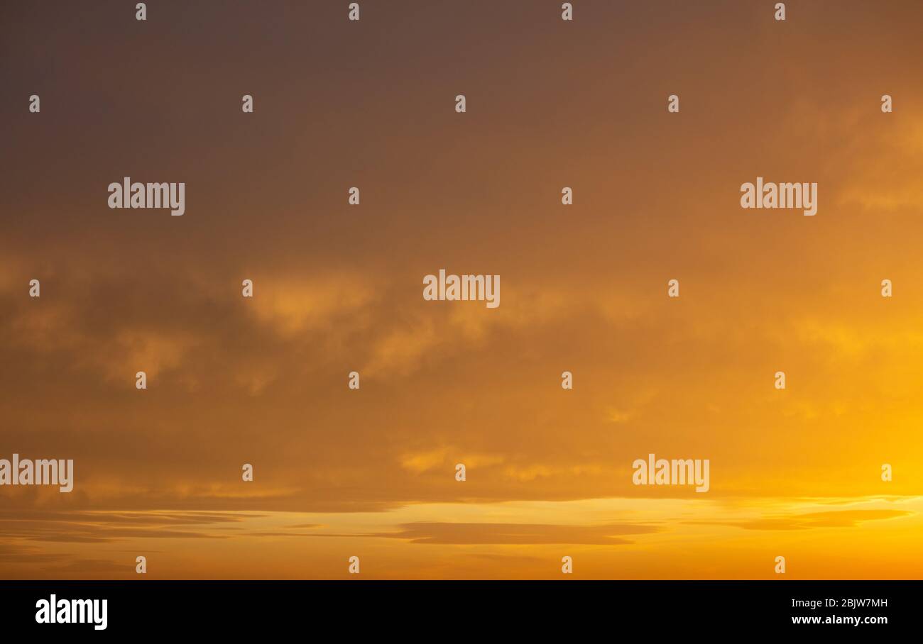 Sunset sky. Sunrise paints with orange shades the cloudy sky background ...