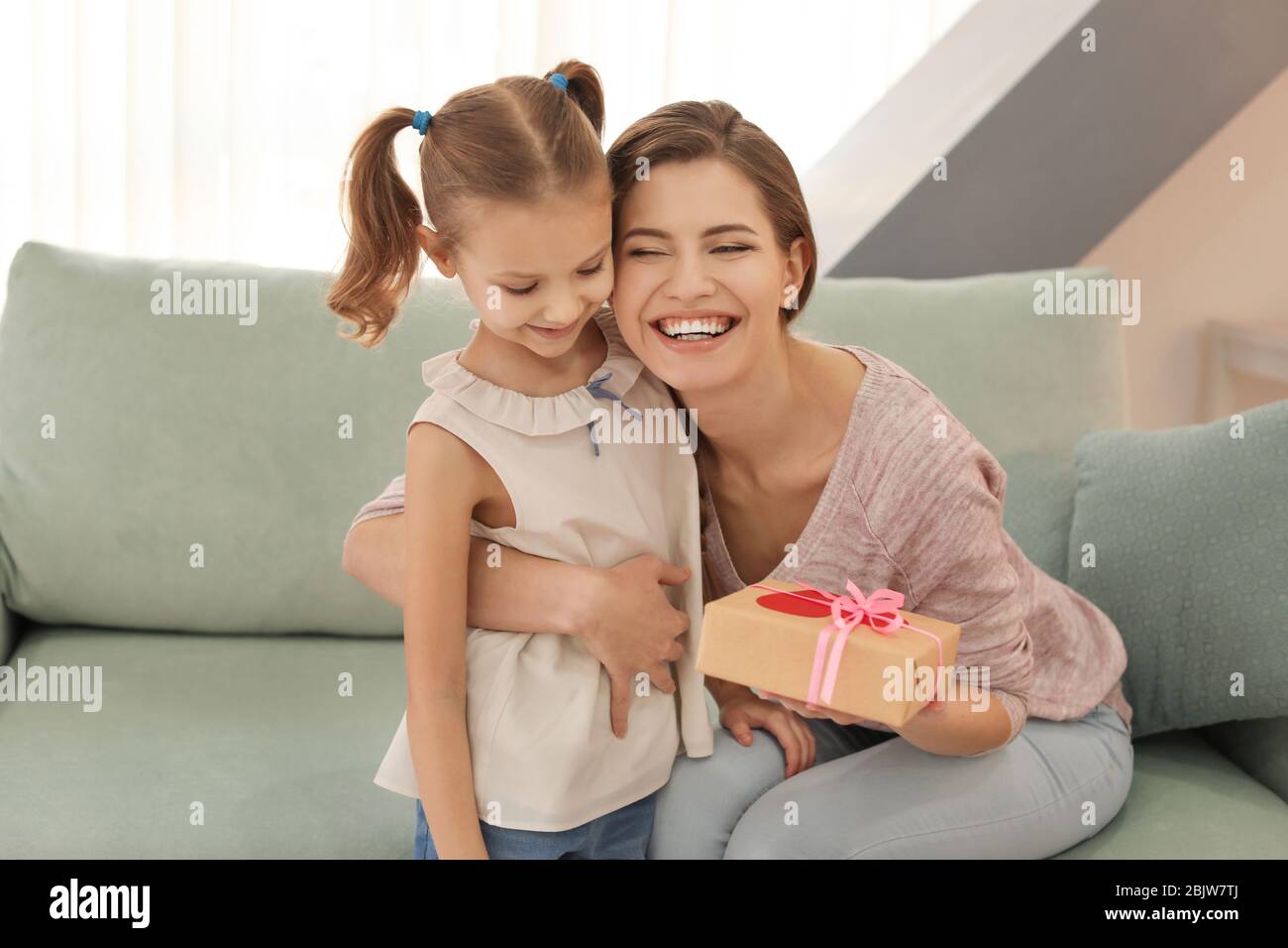 Cute little girl greeting her mother at home Stock Photo - Alamy