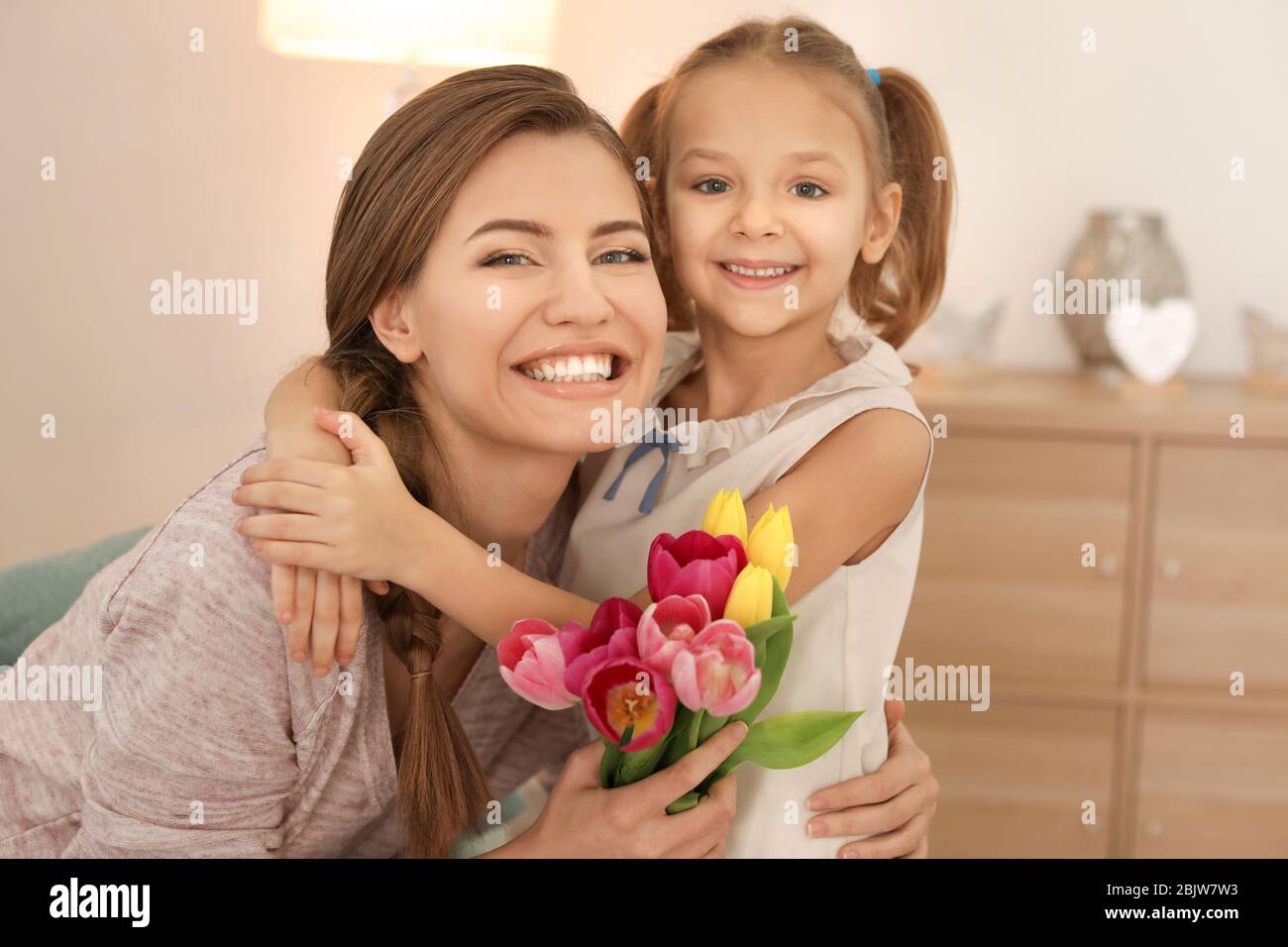 Cute little girl greeting her mother at home Stock Photo - Alamy